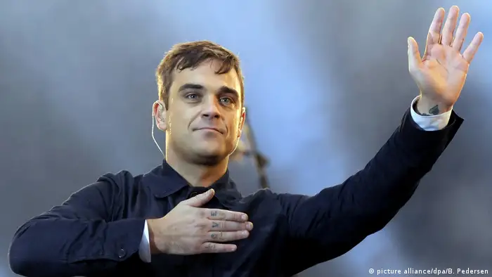 Robbie Williams with his hand on his heart (Photo: picture alliance/dpa ...