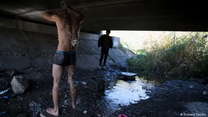 A man washing under a bridge